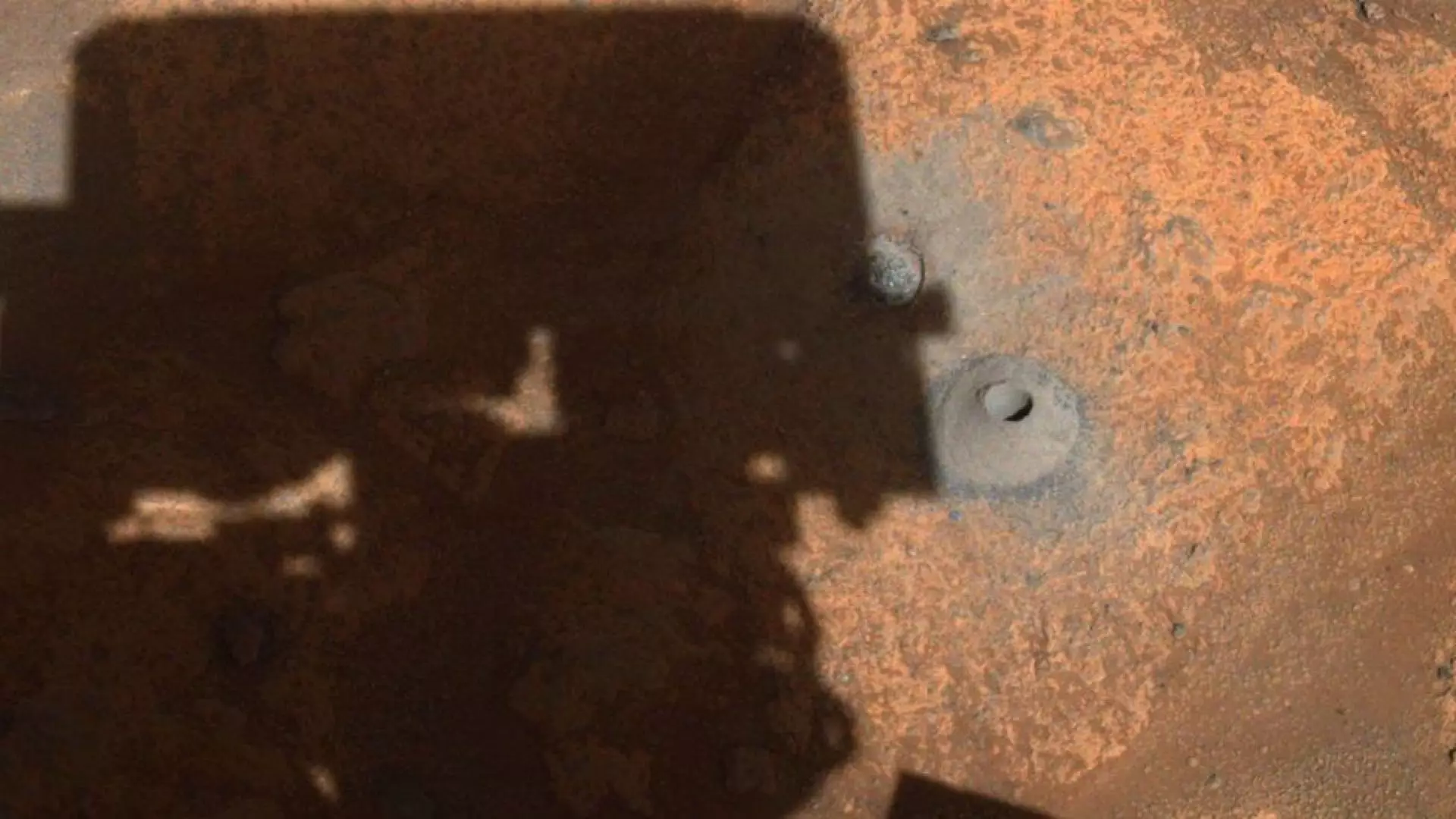 Rover perfurando um buraco em Marte