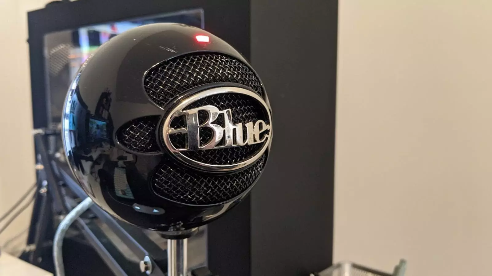Blue Snowball-mikrofon på et stativ ved siden af en computer