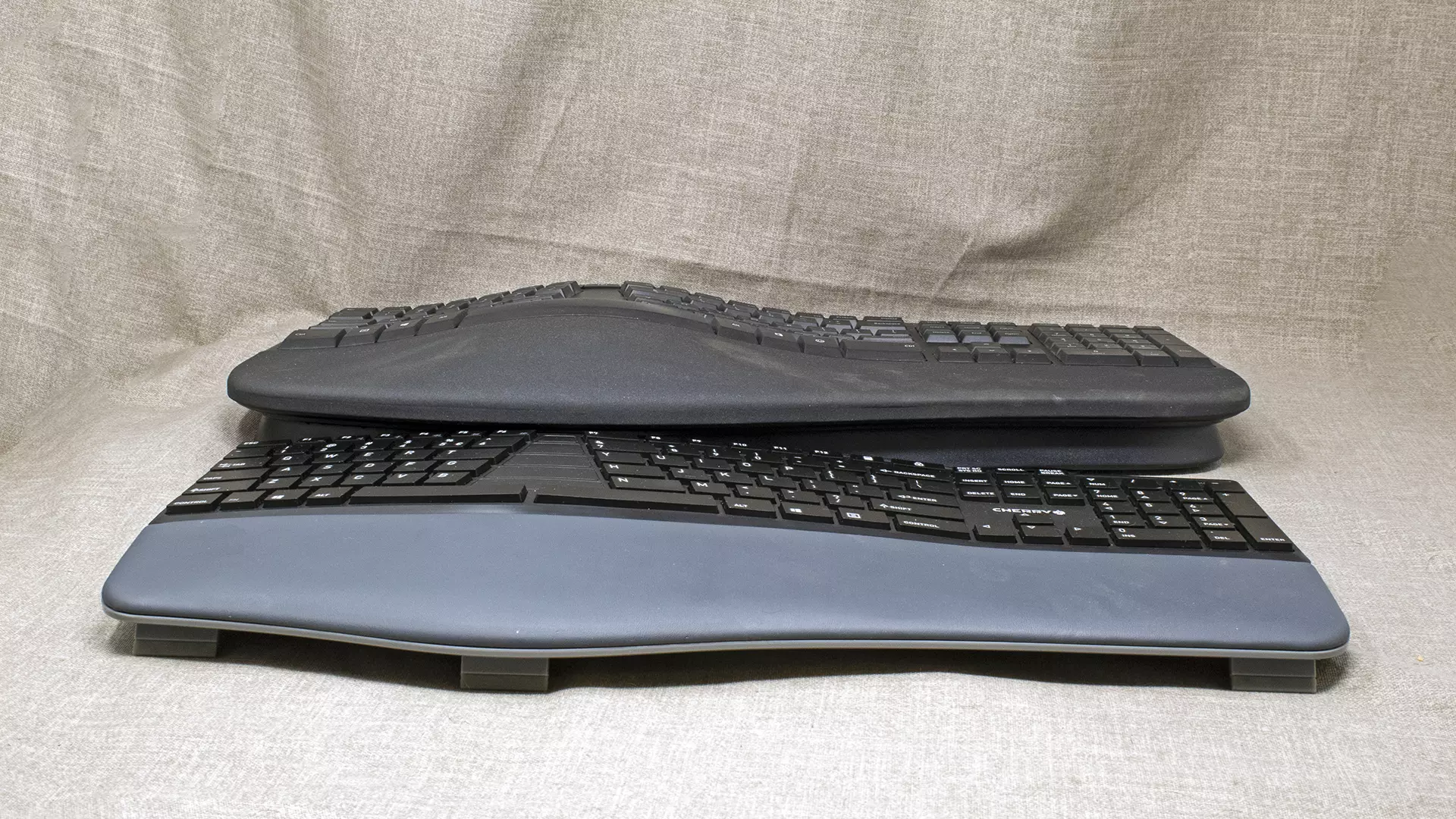 两个键盘，一个的倾斜度和弯曲度远低于另一个。