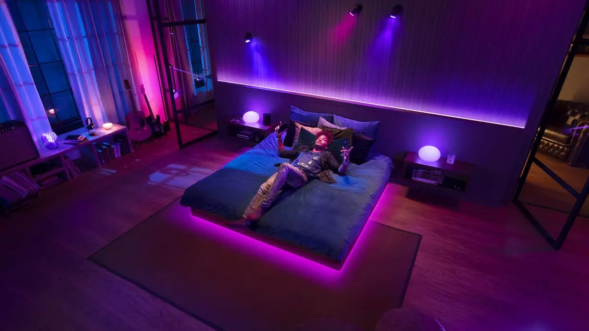 Një burrë i shtrirë në një shtrat i rrethuar nga dritat Philips Hue