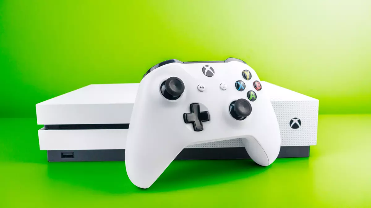 動態漸變綠色背景前的白色 Xbox One S 控制台和匹配控制器