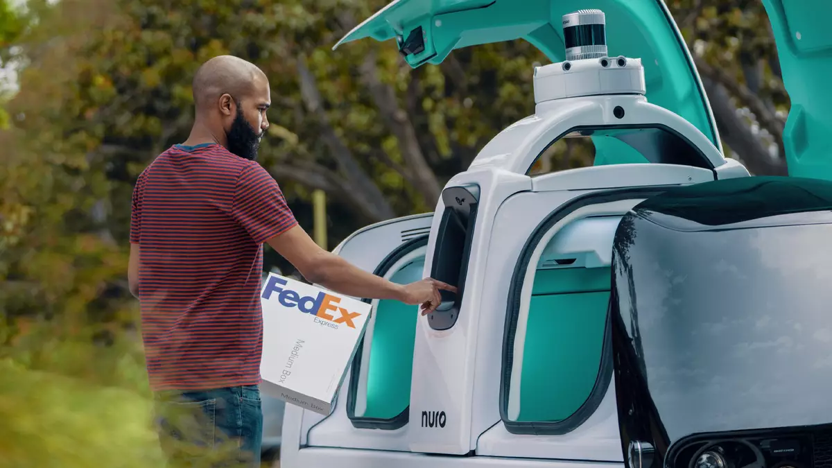 Eine Person, die ihr FedEx-Paket von einem autonomen Zustellfahrzeug entgegennimmt.