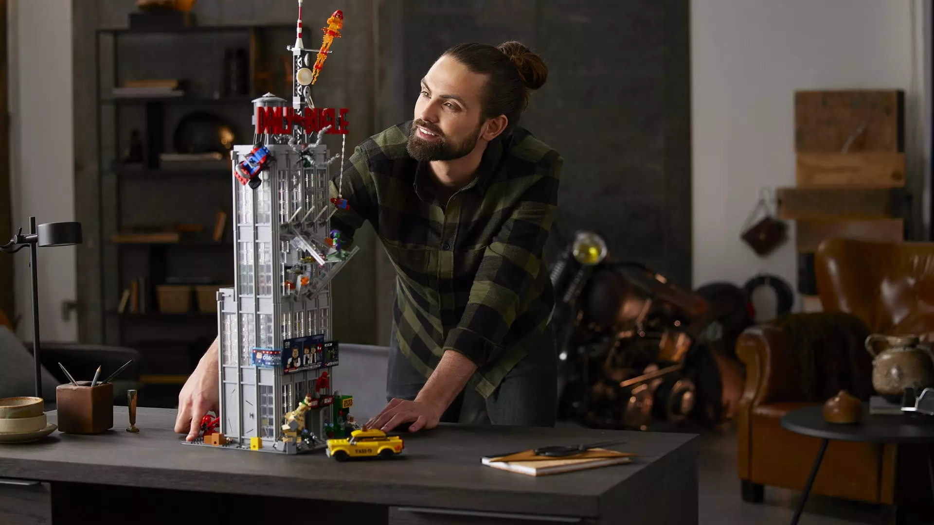 Бараг 3 фут өндөр LEGO Daily Bugle багцын дэргэд зогсож буй эрэгтэй