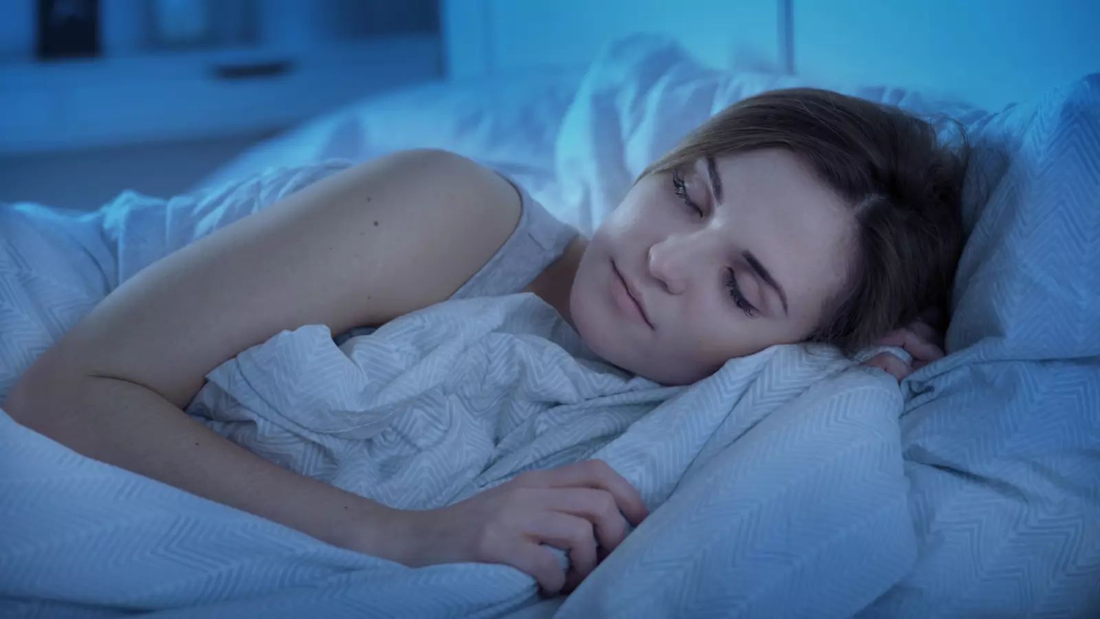 Persona durmiendo tranquilamente en la cama por la noche
