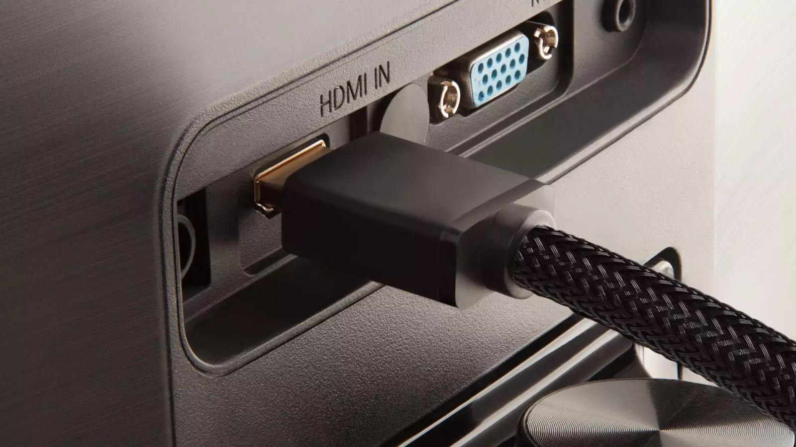 Kabel HDMI wchodzący do portu z tyłu monitora