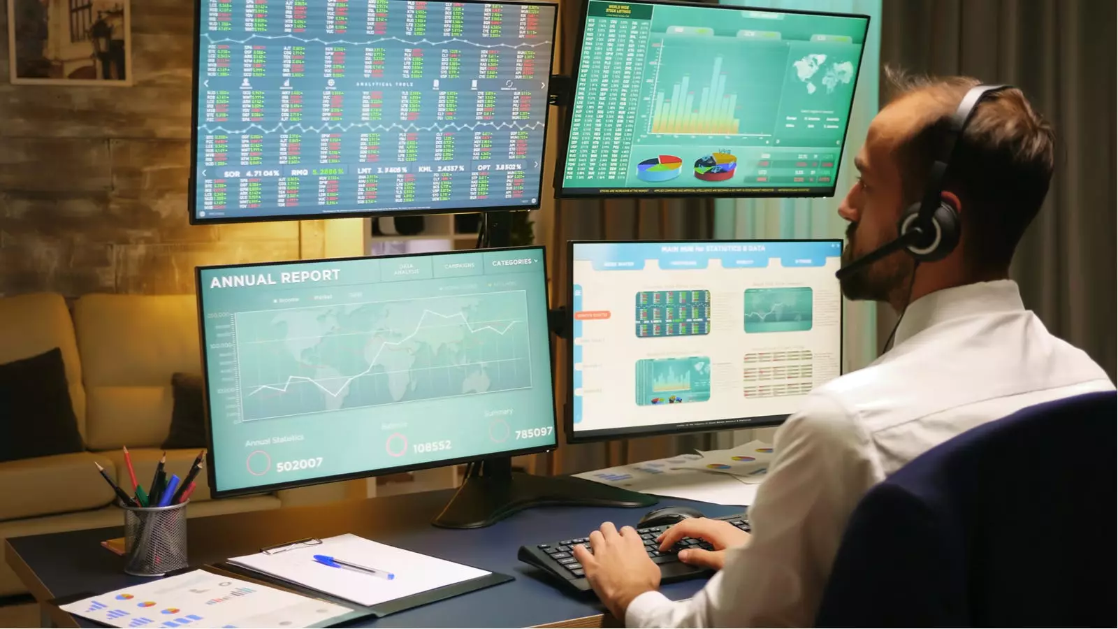 Pedagang saham mengoperasikan beberapa monitor yang ditumpuk di atas satu sama lain