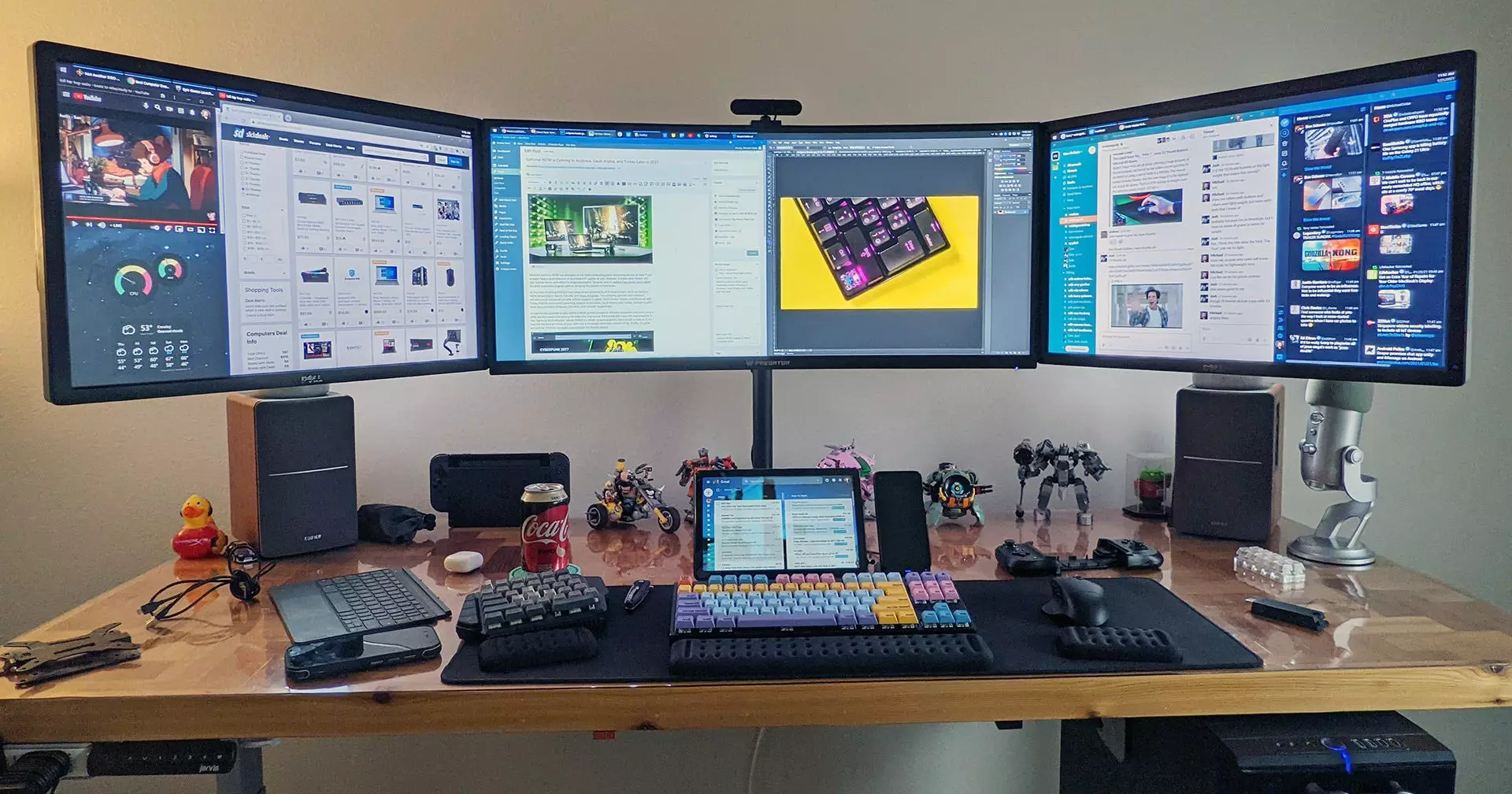 Biroul cu triplu monitor al lui Michael cu tabletă dedesubt.