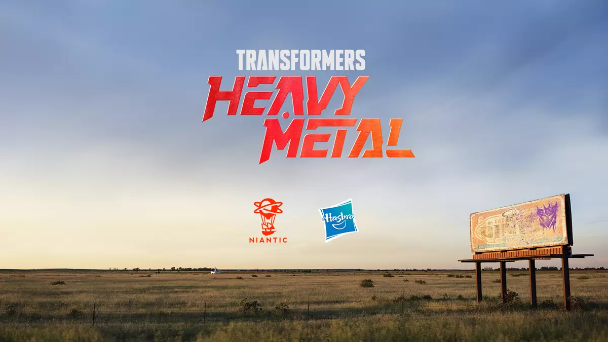 Лагатып гульні Transformers: Heavy Metal перад пыльным заходнім пейзажам, знятым з выцвілым білбордам