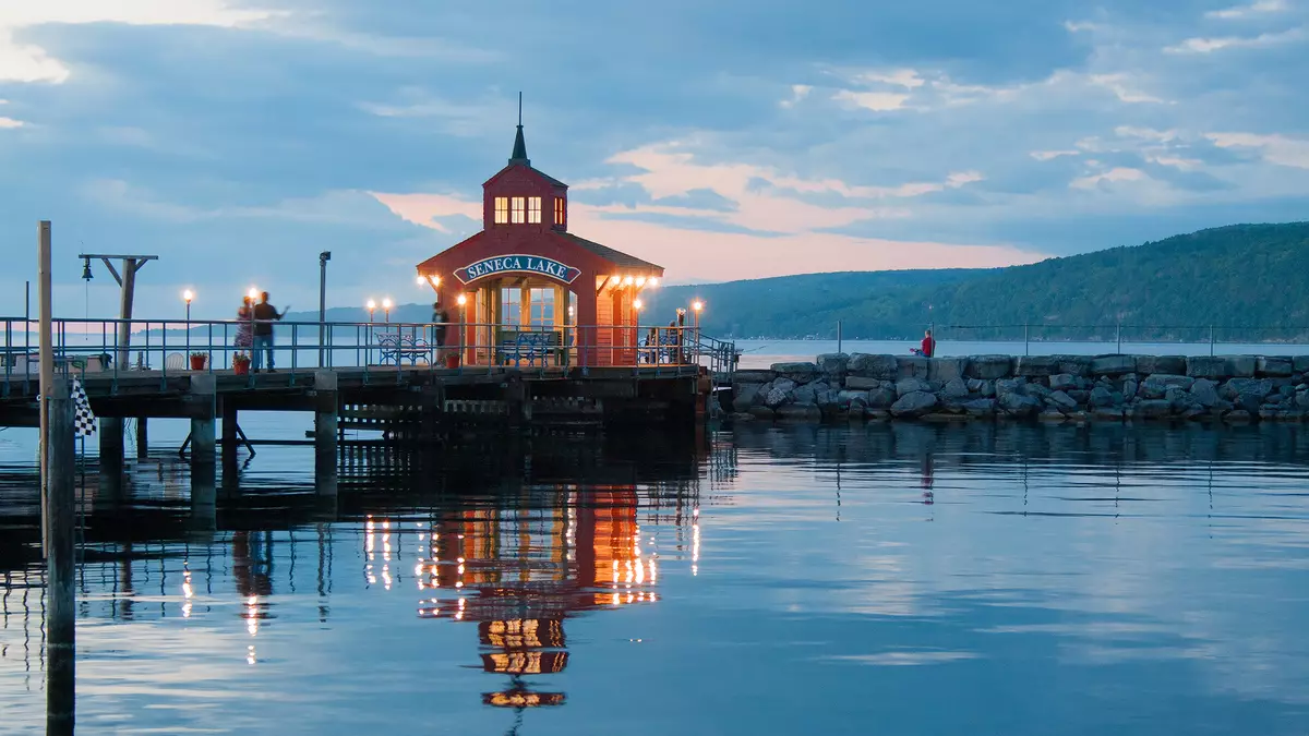 Pier på Seneca Lake med glødende lys ved solnedgang
