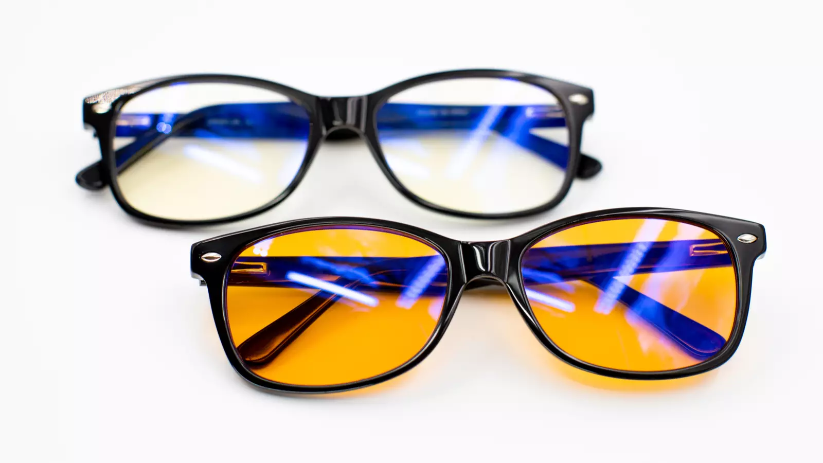 Două perechi de ochelari de blocare a luminii albastre pe un fundal alb