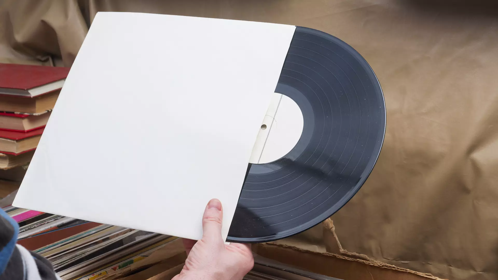 Retrostilt bilde av en samling gamle vinylplater-lp-er med ermer på trebakgrunn. Bla gjennom vinylplatesamlingen. Musikk bakgrunn.
