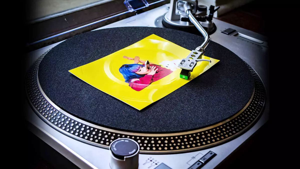 Gambar vignetted kertu pos vinyl kuning ing turntable modern