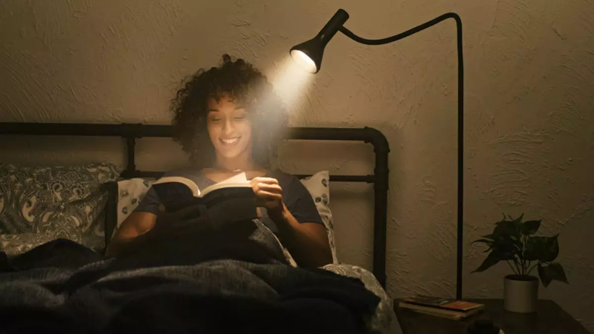Seorang wanita membaca buku di bawah lampu tugas.