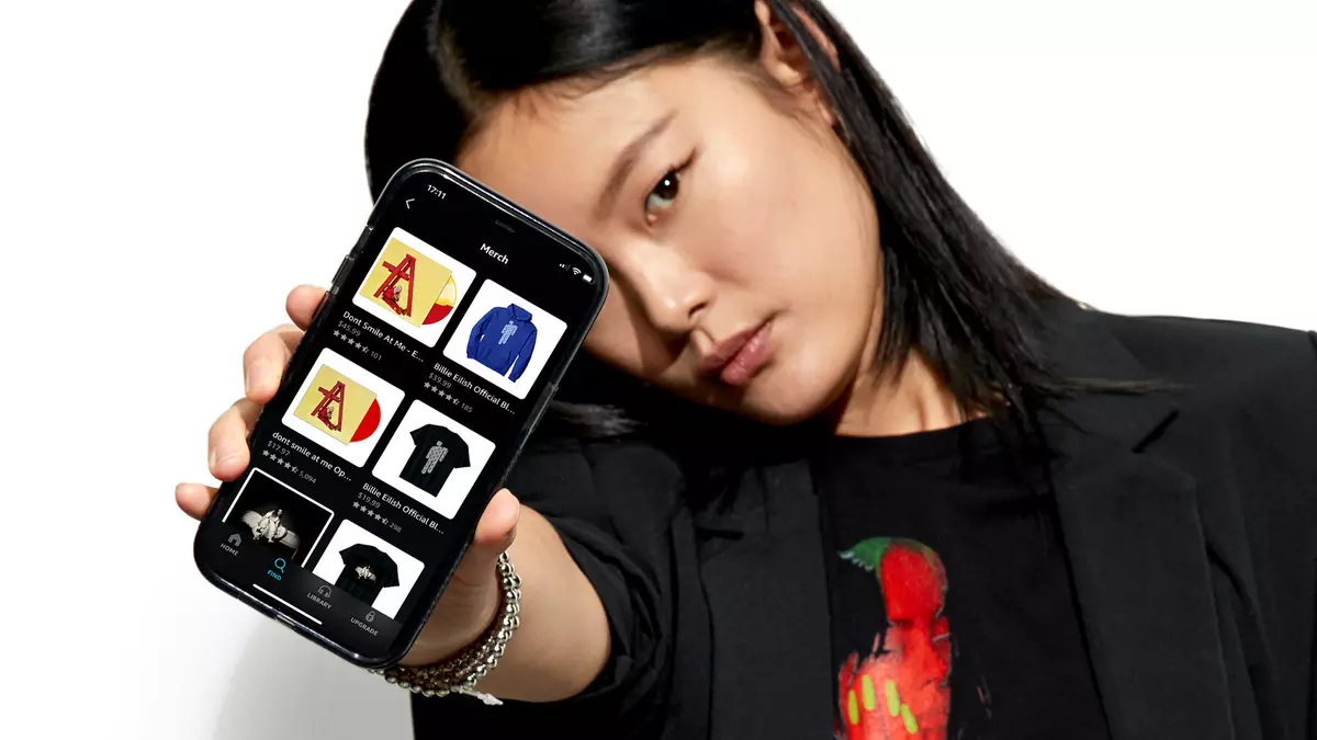 Osoba koja drži aplikaciju Amazon Music na pametnom telefonu koja prikazuje opcije prodaje bendova