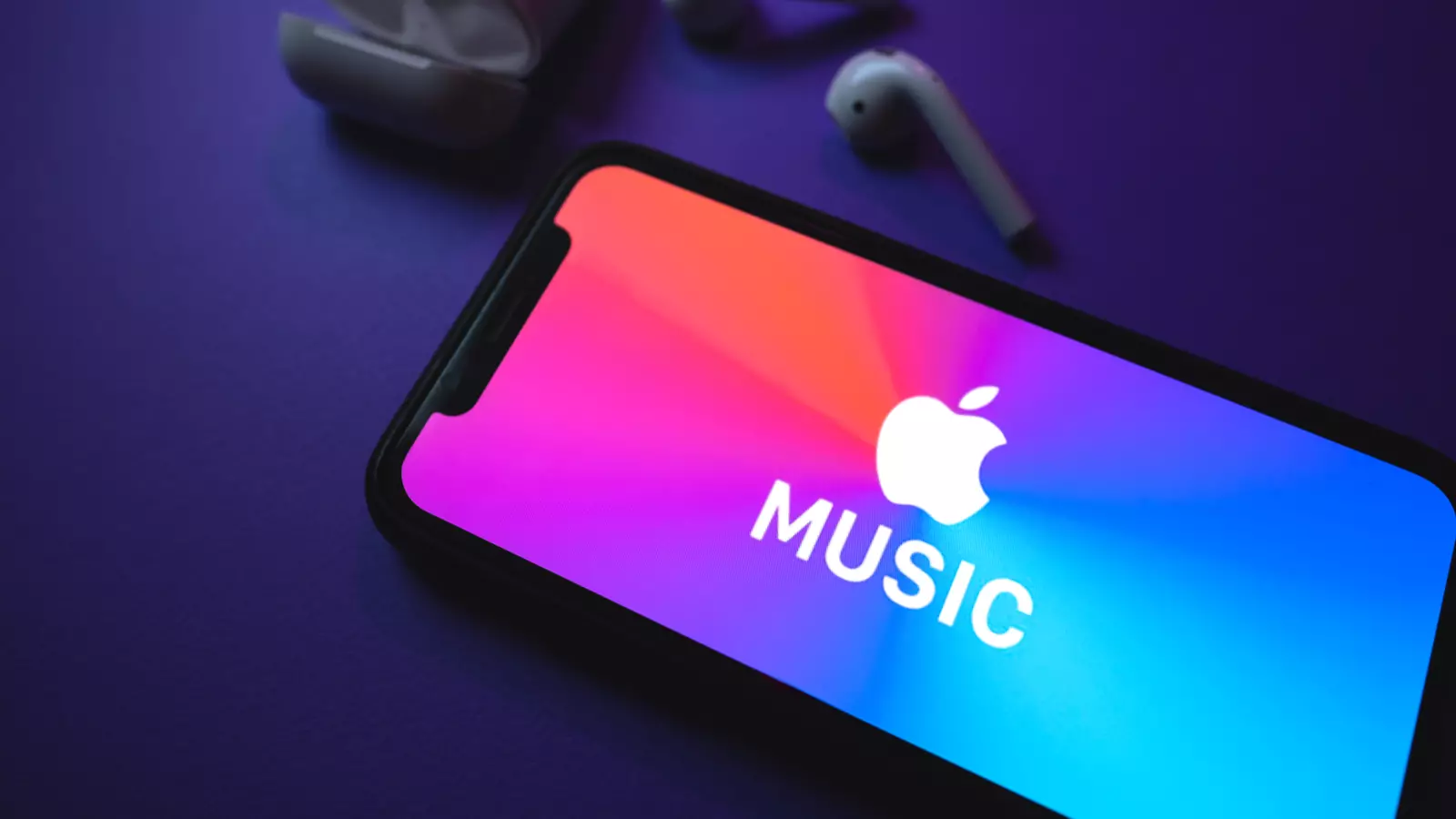 Logo Apple Music sur l'écran du smartphone, avec airpods