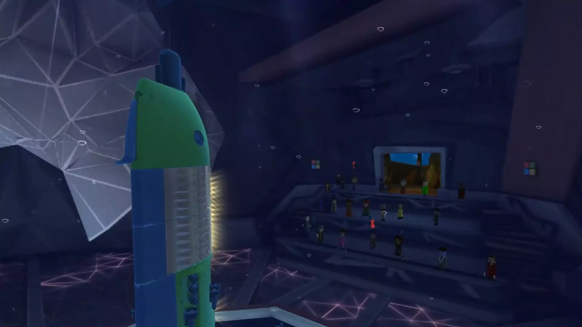 En digital ubåt som reiser seg fra en scene foran en gruppe digitale avatarer.