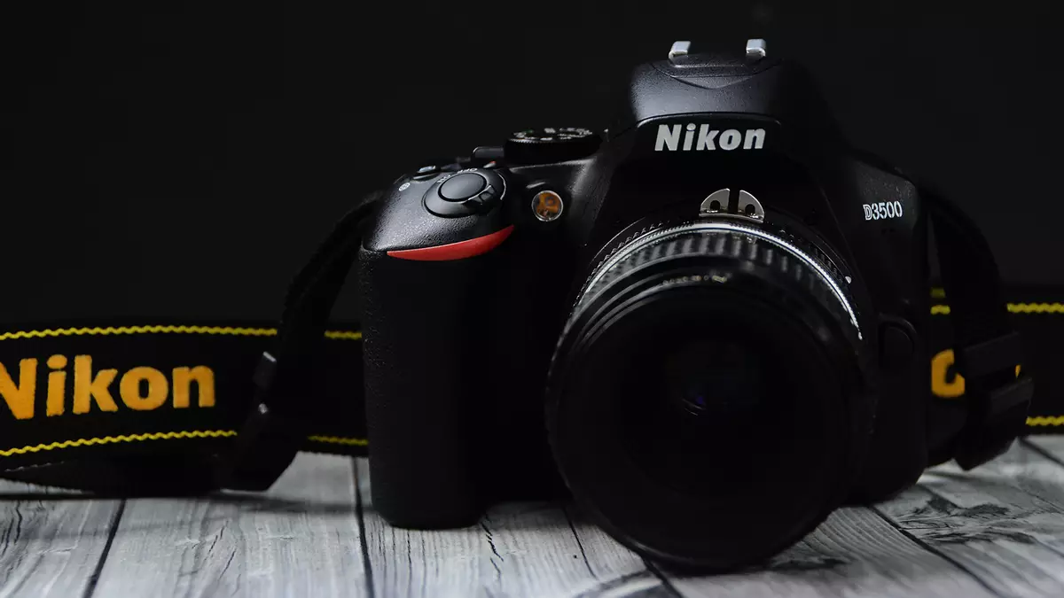 Une photo du reflex numérique Nikon D3500 sur un arrière-plan noir spectaculaire.