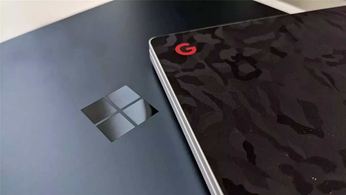 Google Pixelbook s černým krytem značky camo na vrchu Surface Laptop 3