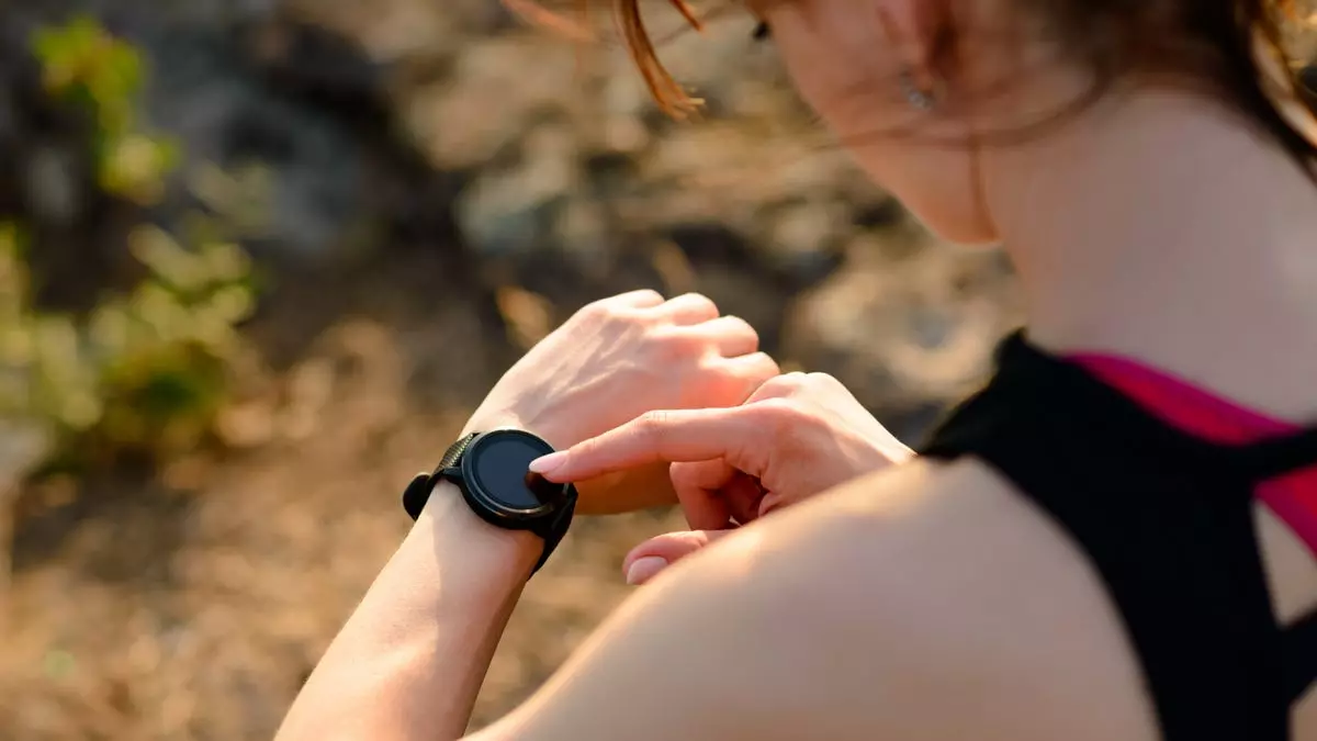Mladá žena běžkyně pomocí Multisport Smartwatch při západu slunce na horské stezce. Detailní záběr na ruce s Fitness Tracker