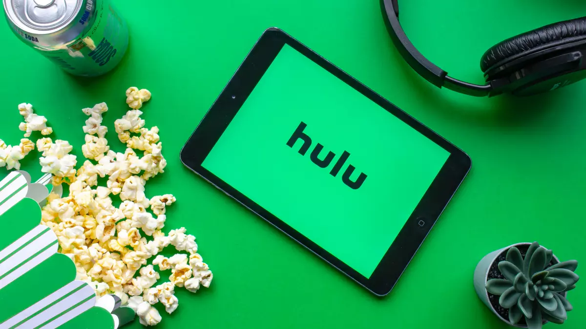 iPad Hulu-ს ლოგოთი ეკრანზე მწვანე ფონზე პოპკორნითა და ყურსასმენებით