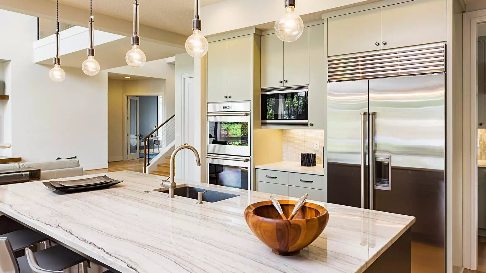 Et smukt moderne køkken med marmorborde og high-end hårde hvidevarer.