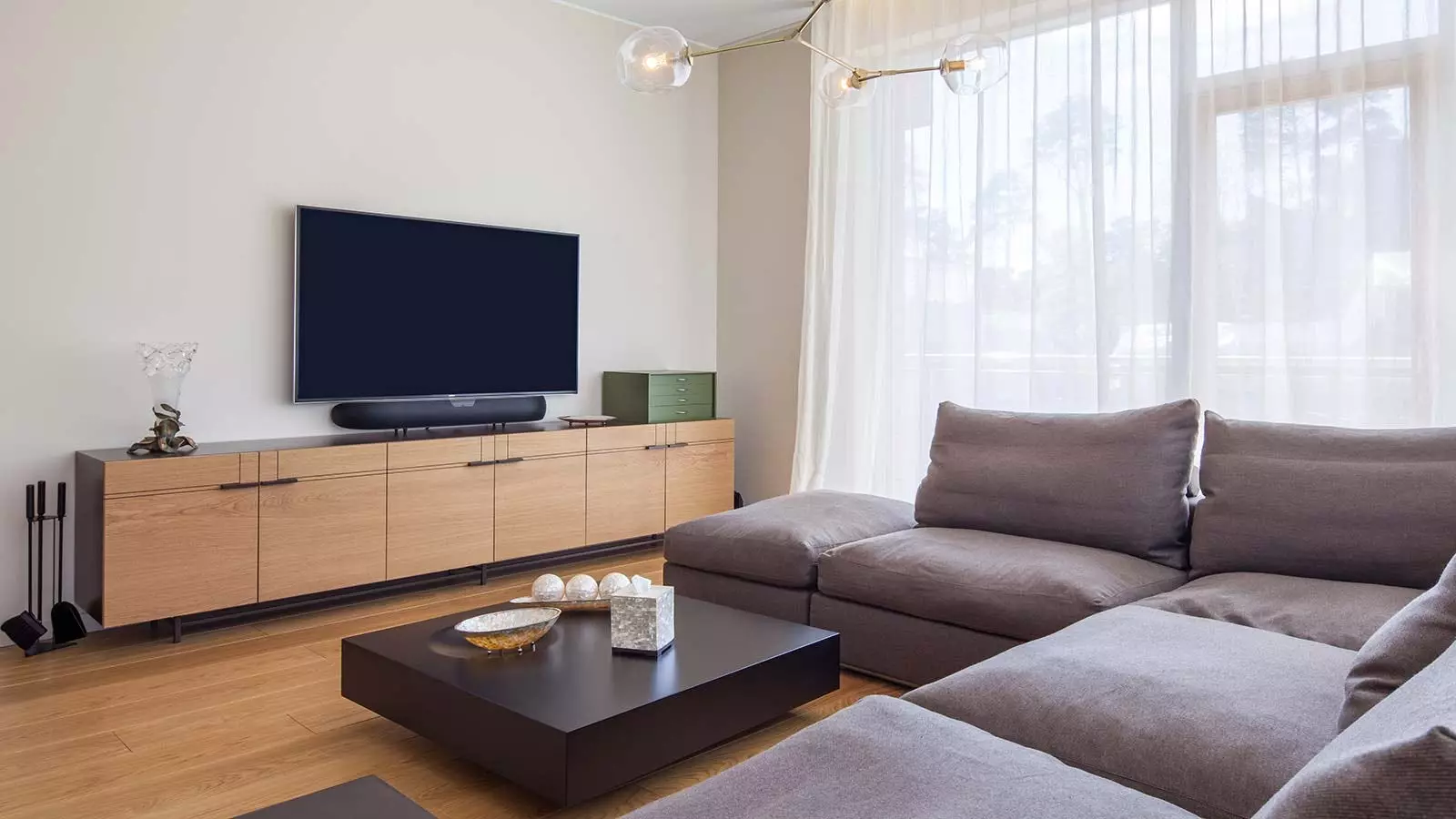 En moderne stue med en sektionssofa og et fladskærms-tv.