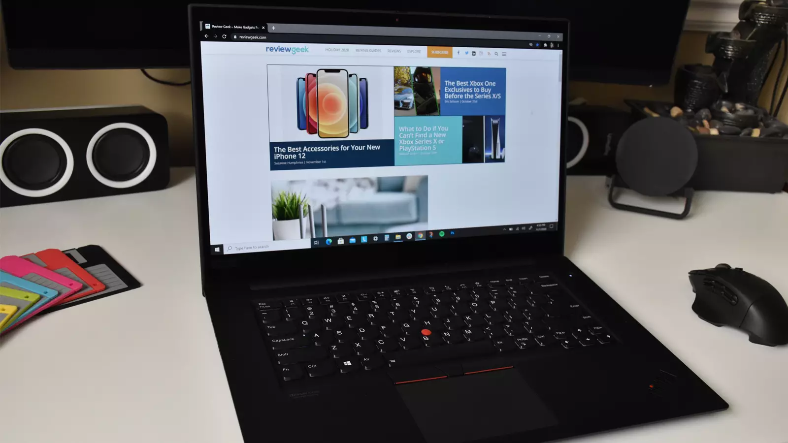 Lenovo ThinkPad X1 Extreme Gen 3 дар мизи сафед дар паҳлӯи муш ва костерҳо
