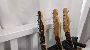 Binnenopname, een close-up van gitaarkoppen bij weinig licht
