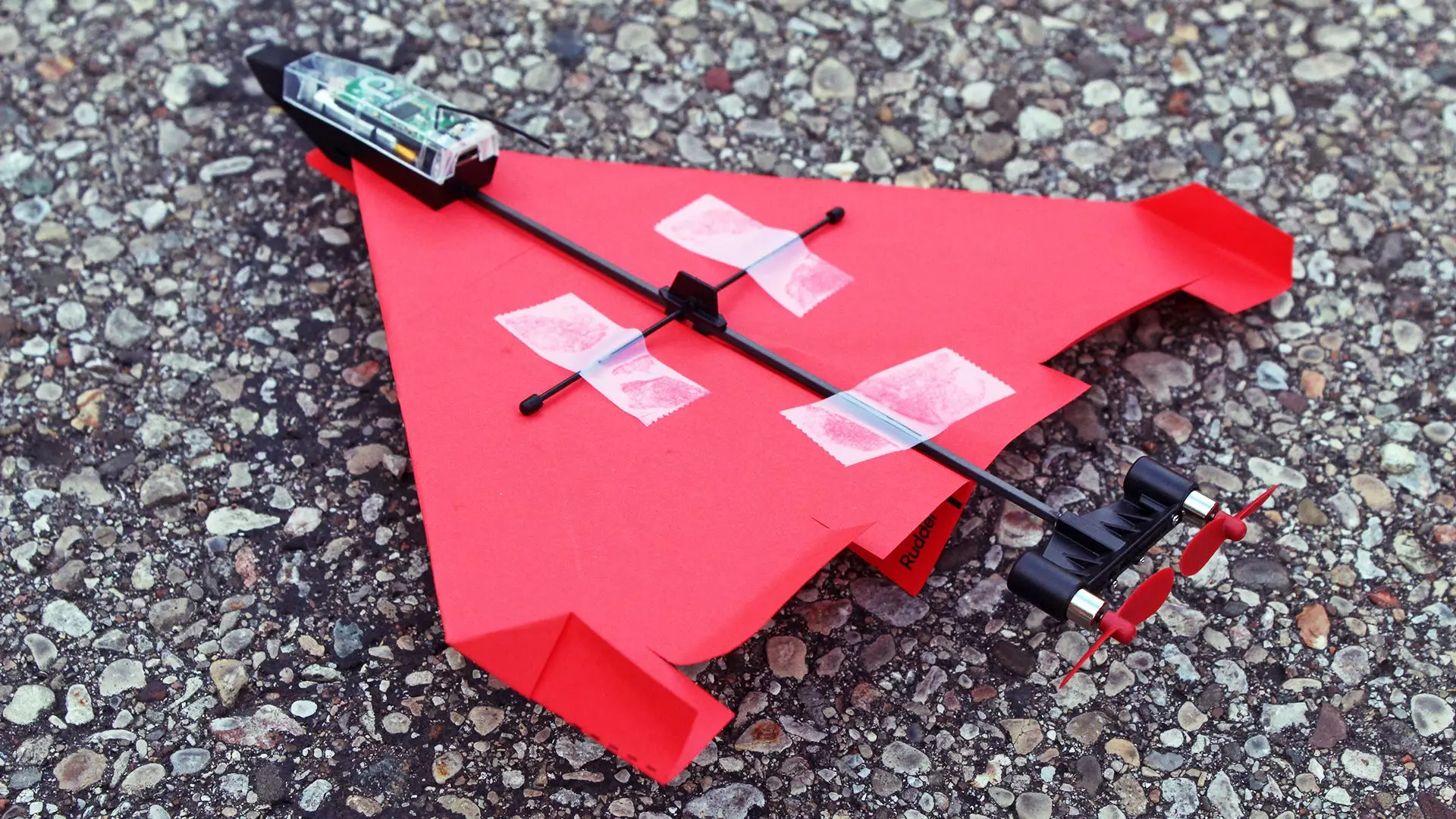 Un avion en papier scotché à un drone ressemblant à un avion RC.