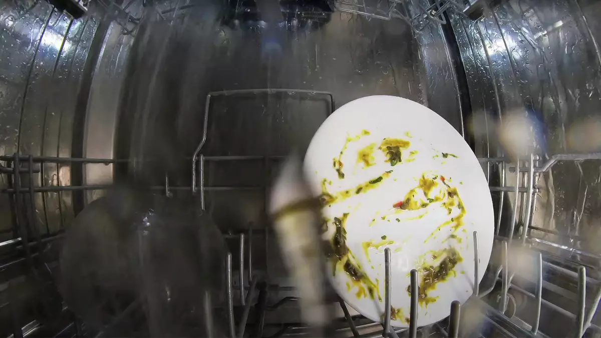 Внутренний вид посудомоечной машины, выполняющей цикл мытья посуды