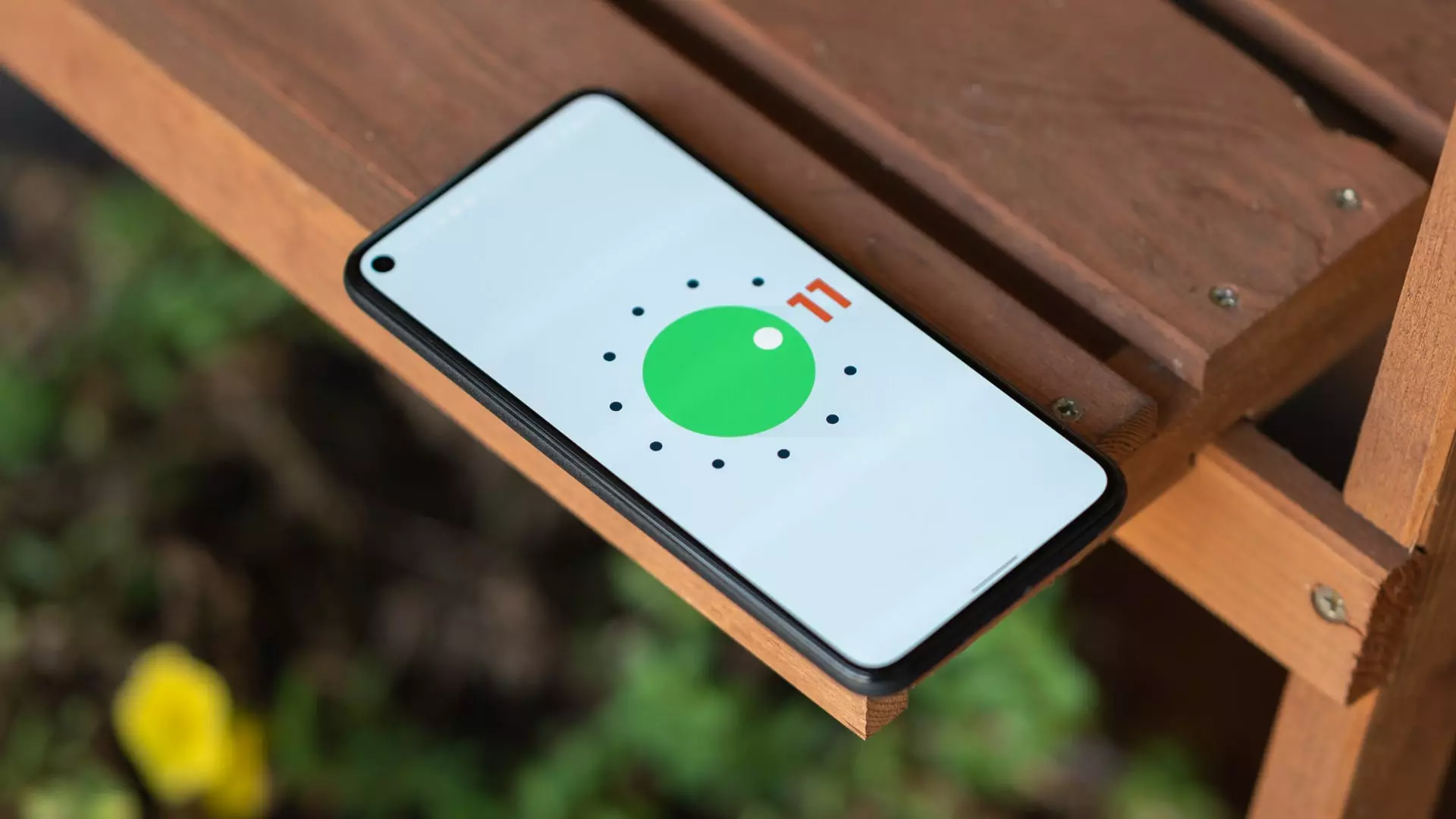 De Pixel 5 op in houten tafel mei it Android 11 easter egg-skerm.