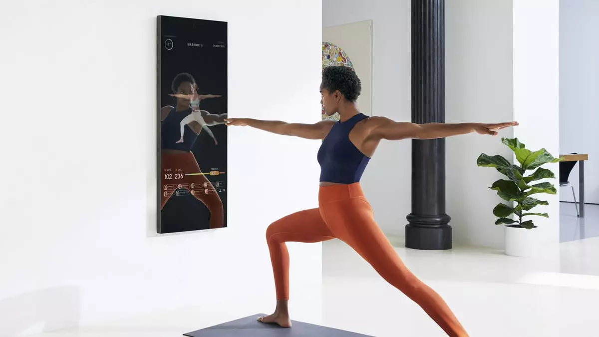 una model posa mentre utilitza un entrenador de fitness digital Mirror