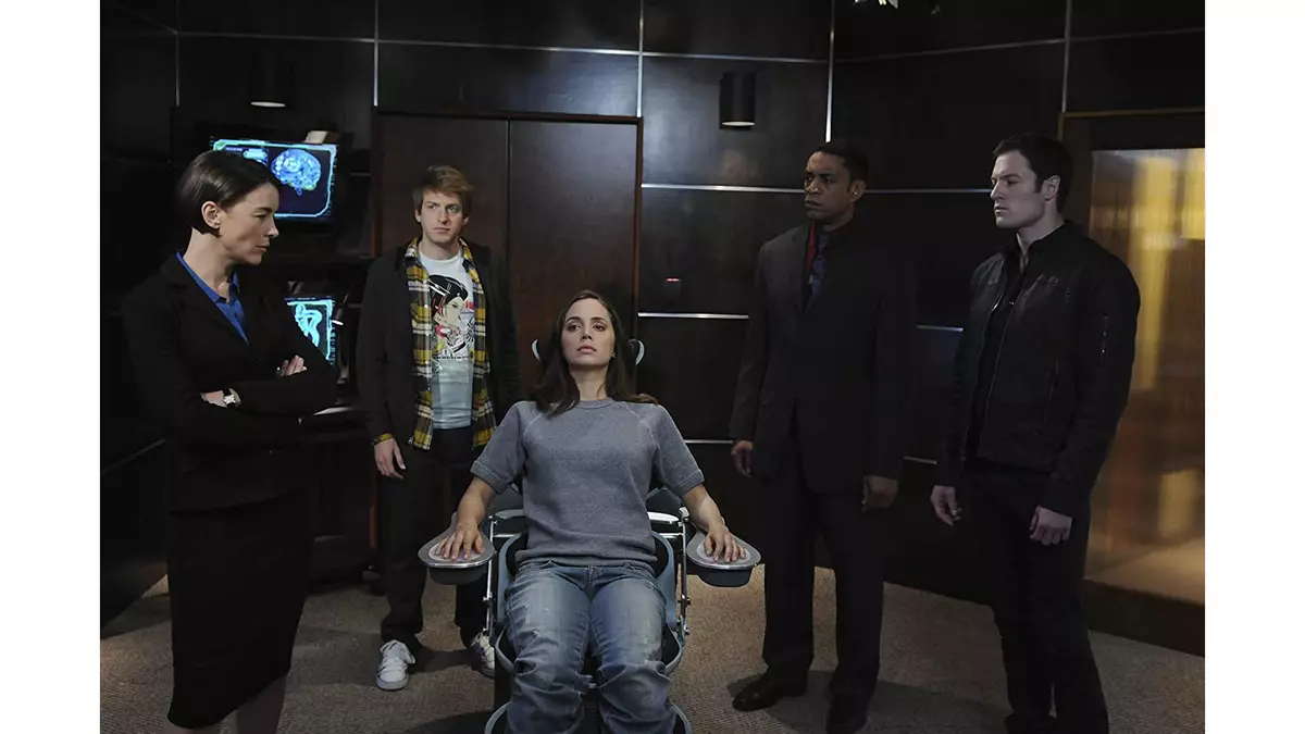 Babaház karakterek állnak egy szobában Eliza Dushku karaktere körül egy széken