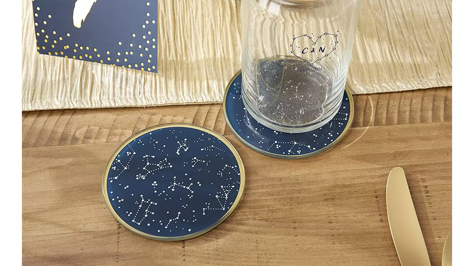 Gouden, witte en marineblauwe onderzetters met gouden rand op tafel met een kopje