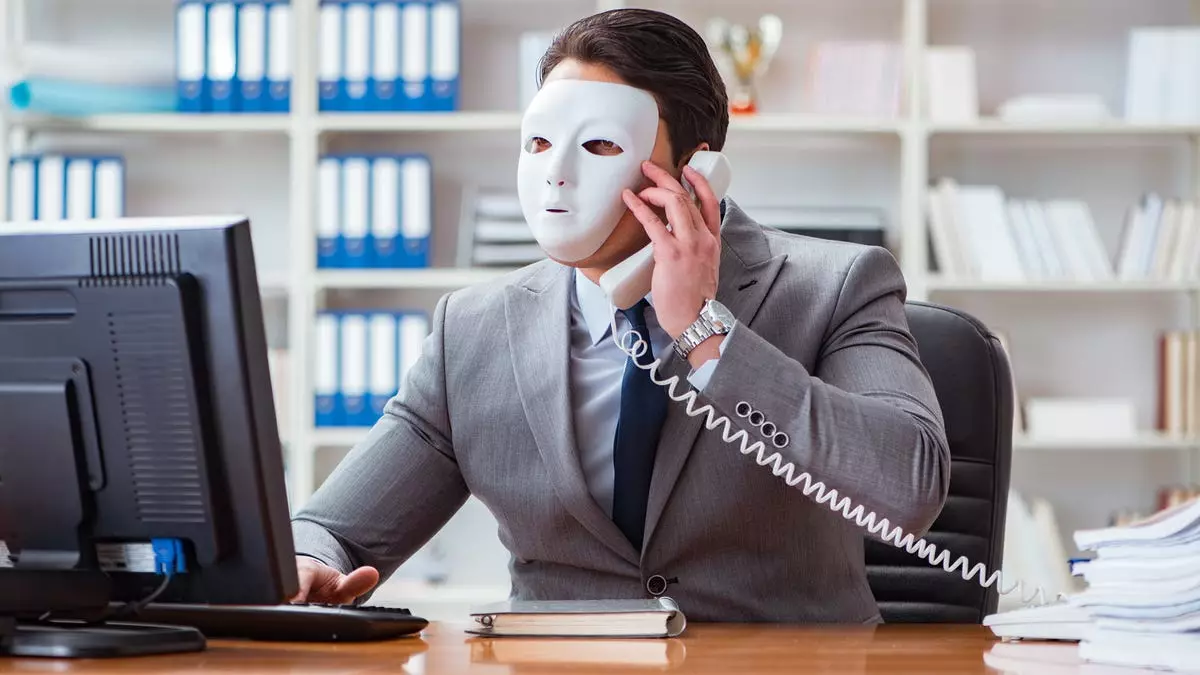 Un home cunha máscara facendo unha chamada telefónica.