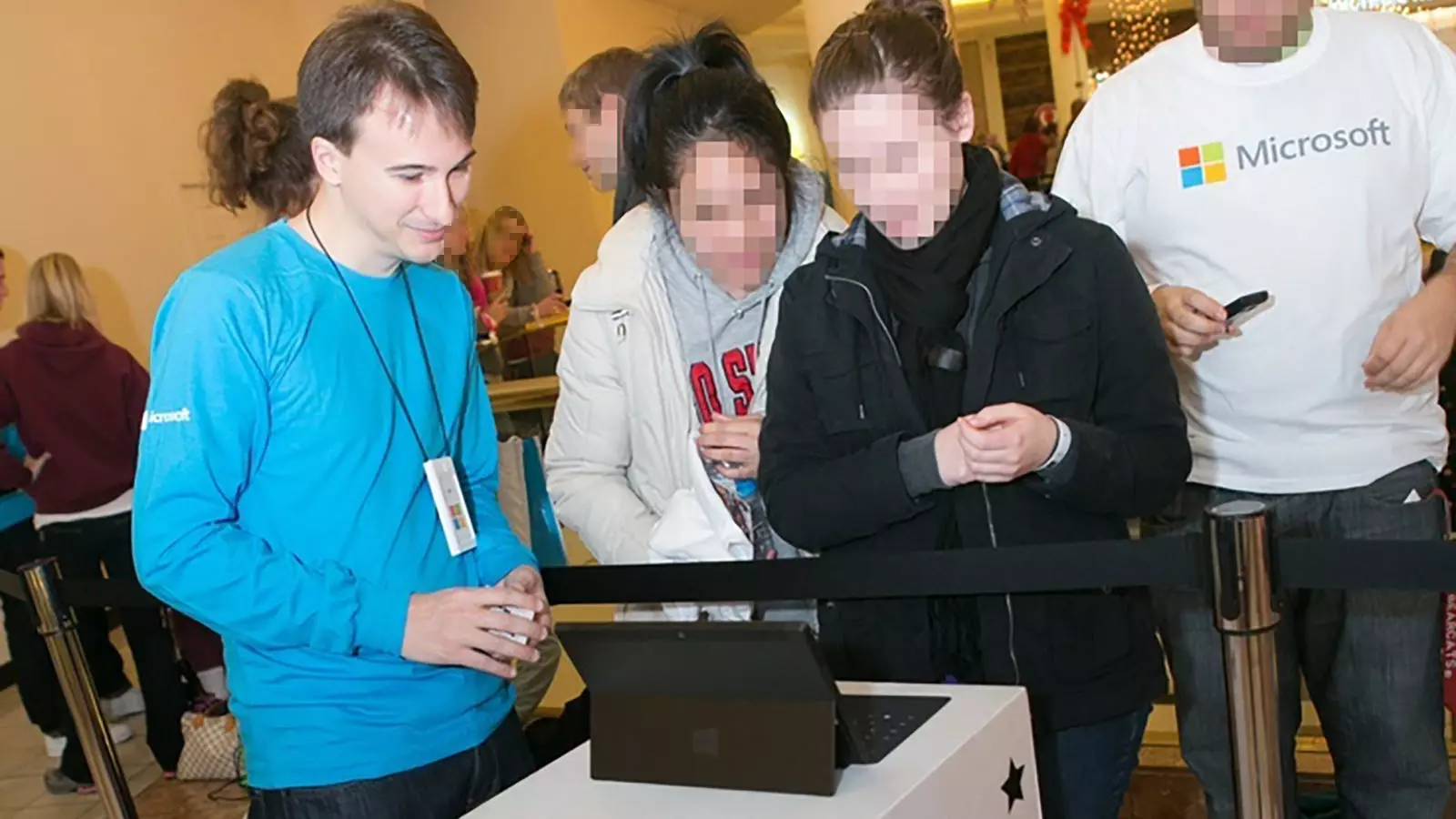 Kirjoittaja seisoo kahden ihmisen vieressä katsomassa Surface RT:tä.