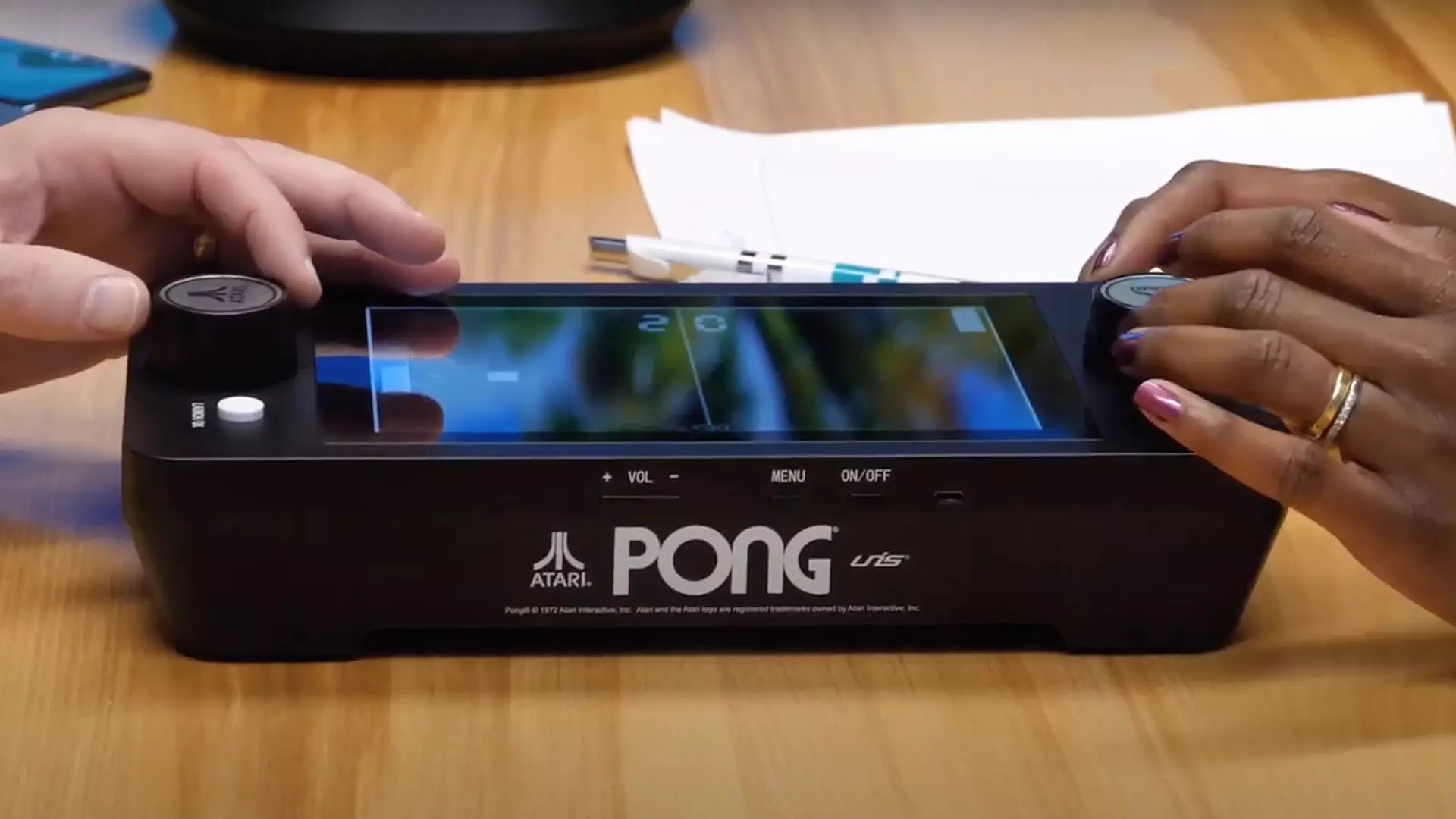 Uma máquina portátil 'Pong' em uma mesa de centro.