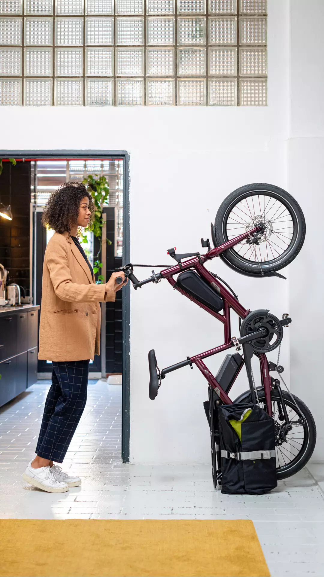 Person som oppbevarer sykkelen vertikalt i en moderne lys leilighet
