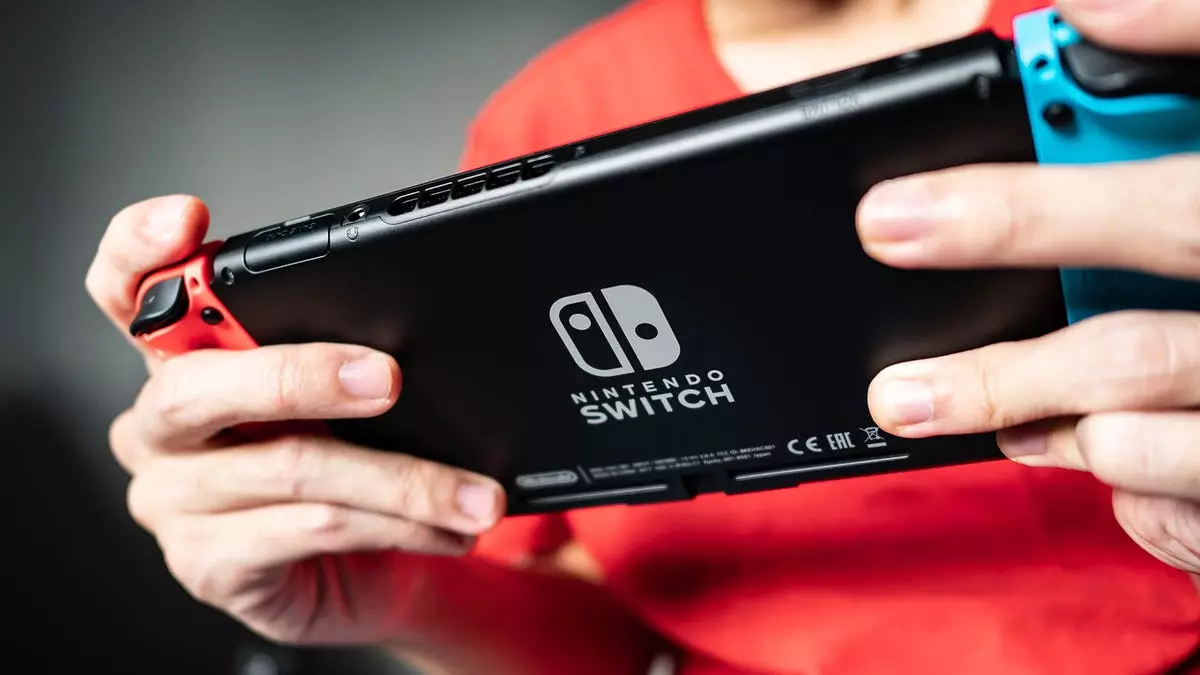Sëtzend Persoun spillt den Nintendo Switch