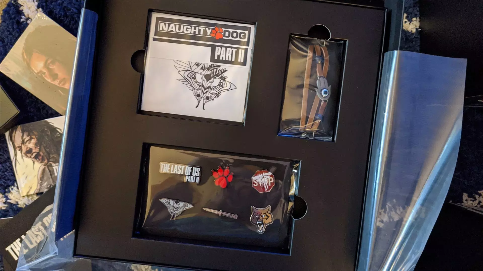Nálepky, špendlíky a náramek ze sběratelské edice The Last of Us Part II