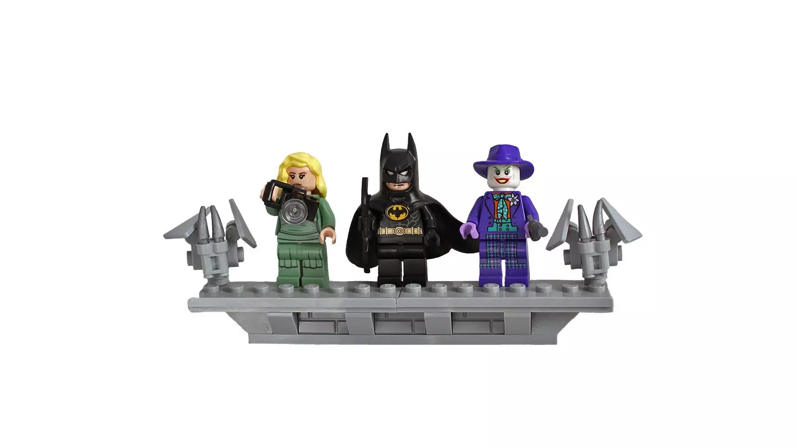 Крупный план Вики Вейл, Бэтмена и Джокера в форме LEGO, стоящих рядом с горгульями LEGO.