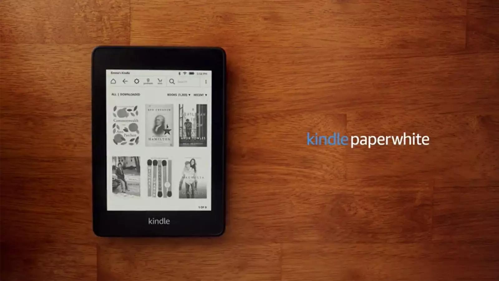 Kindle Paperwhite viser bogvalg, mens de ligger på en træoverflade