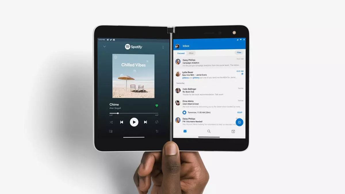 Microsoft Surface Duo, kun Spotify sur unu ekrano kaj Outlook sur la alia.