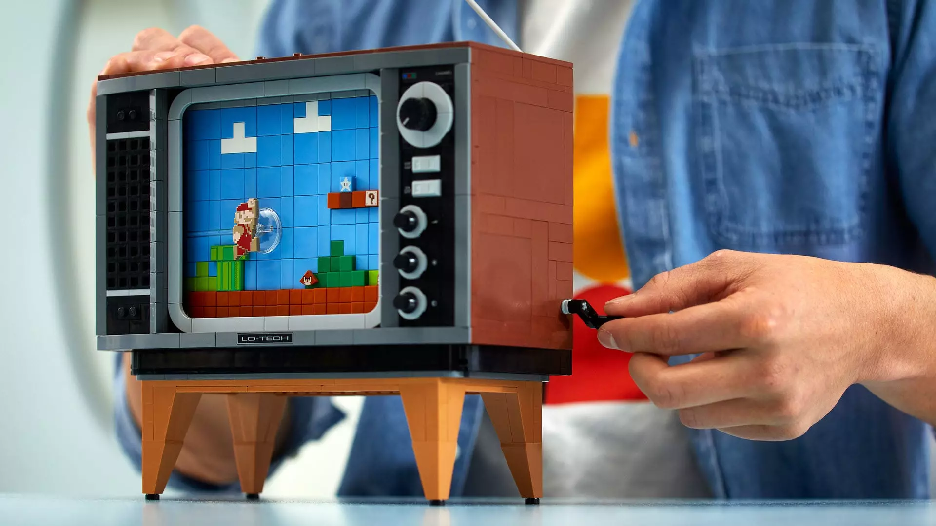 Un primo piano della LEGO TV, mentre qualcuno fa girare a mano lo schermo.