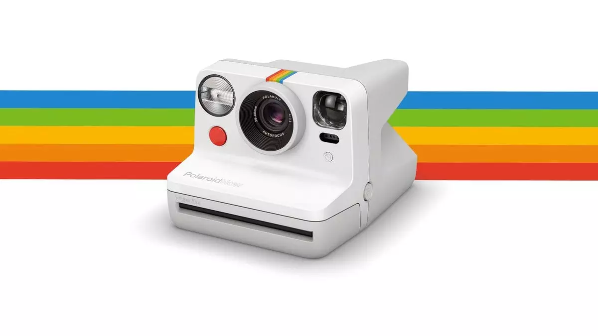 Balta Polaroid kamera vaivorykštės dryžuotame fone.
