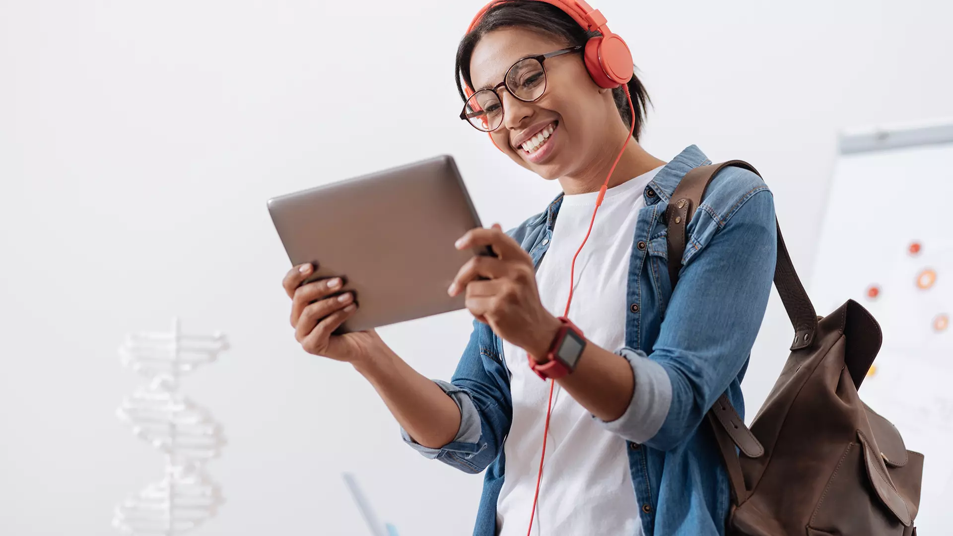 Een studente luistert naar muziek terwijl ze naar haar tablet kijkt.