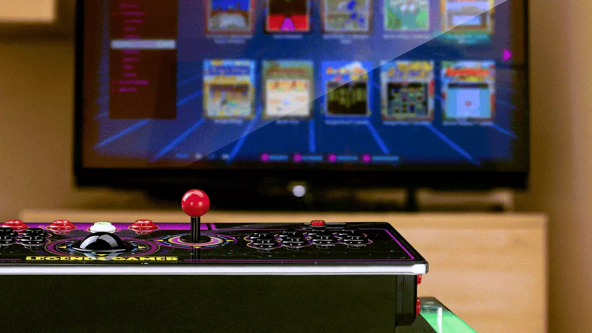 Um console sem fio que se assemelha a um deck de controle de arcade, conectado a uma TV