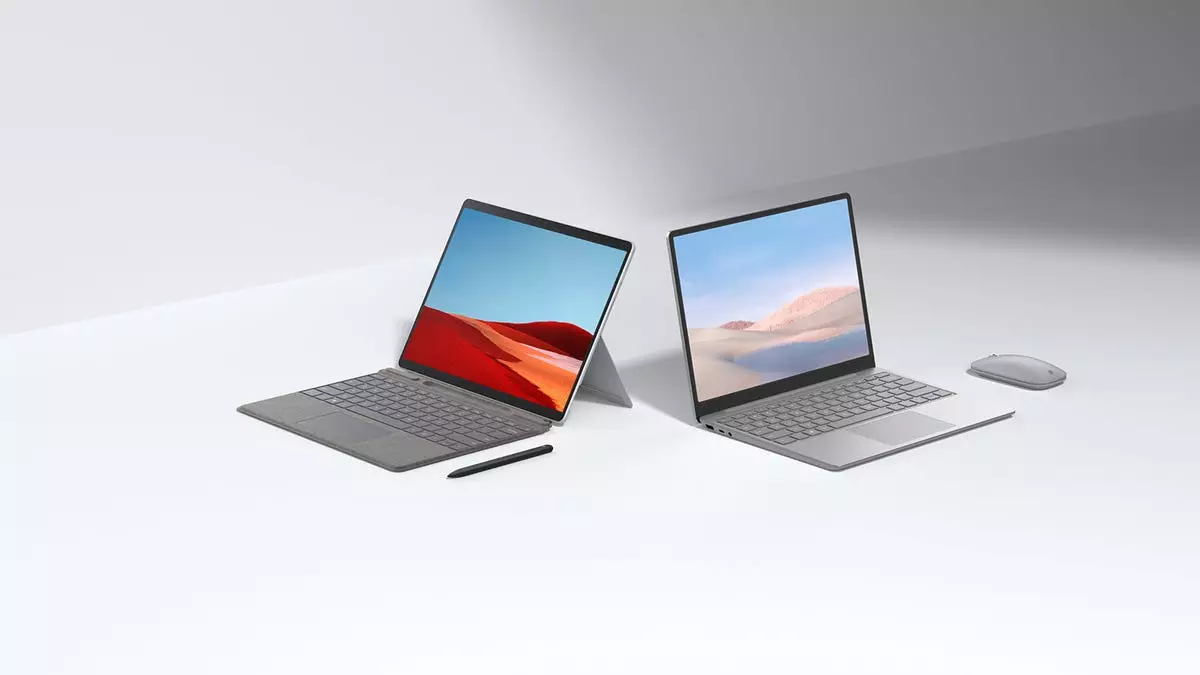 Surface Pro X එකක් Surface Laptop Go සහ mouse එක අසල.
