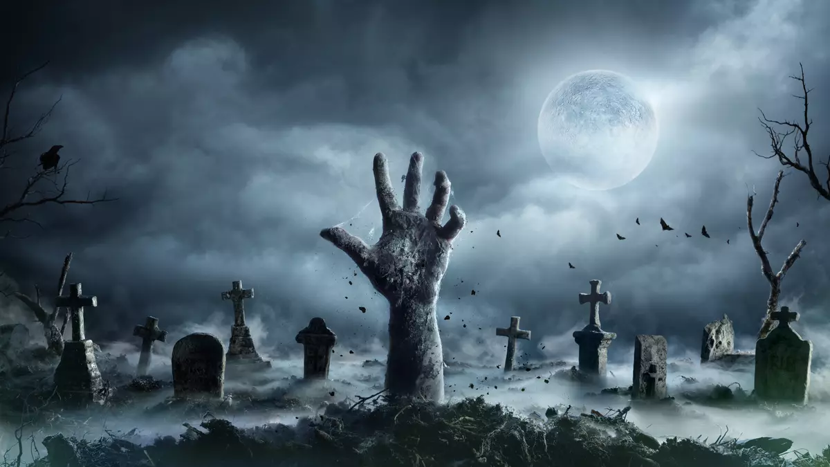 Man de zombie saíndo dun cemiterio nunha noite espeluznante