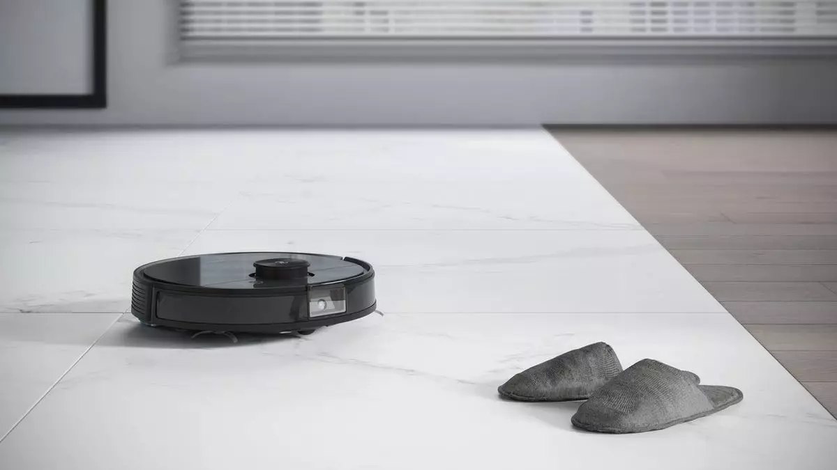 Một máy hút bụi robot Ecovacs tránh một đôi dép đi trong nhà.
